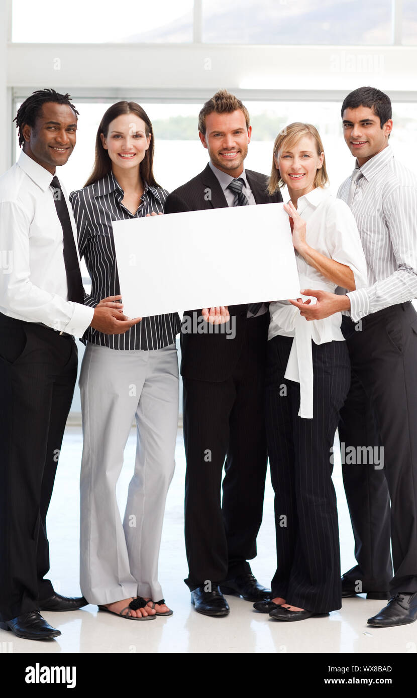 Multi-ethnic business people showing a big white card Stock Photo - Alamy