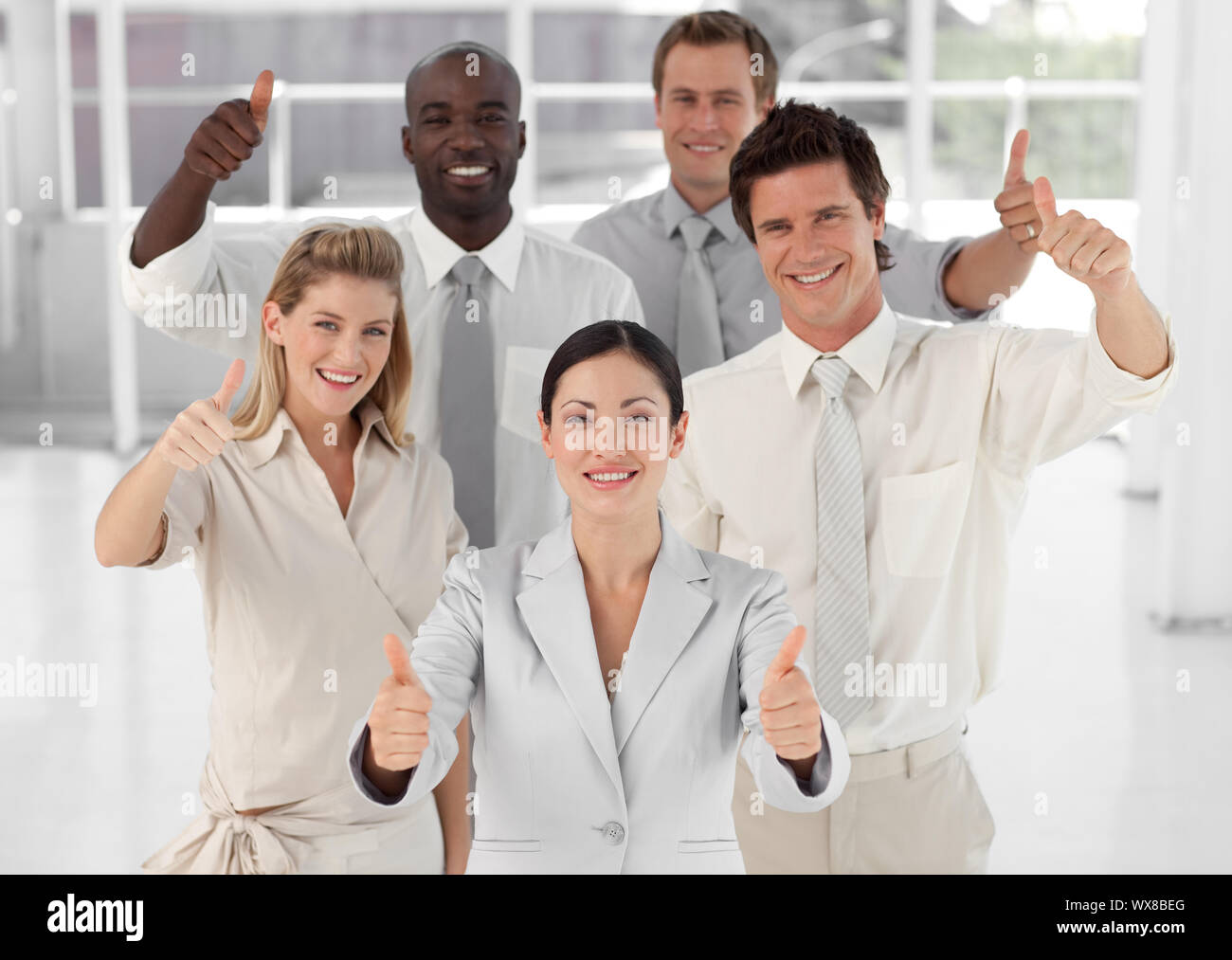 Positive Business Team Smiling and Holding up Thumbs to camera Stock ...