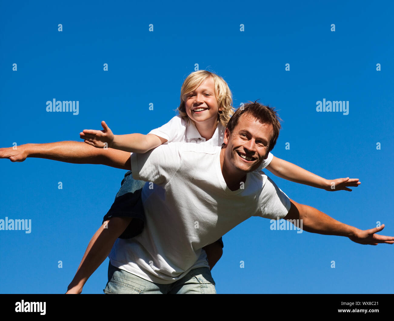 Young man giving young boy piggyback ride Stock Photo - Alamy