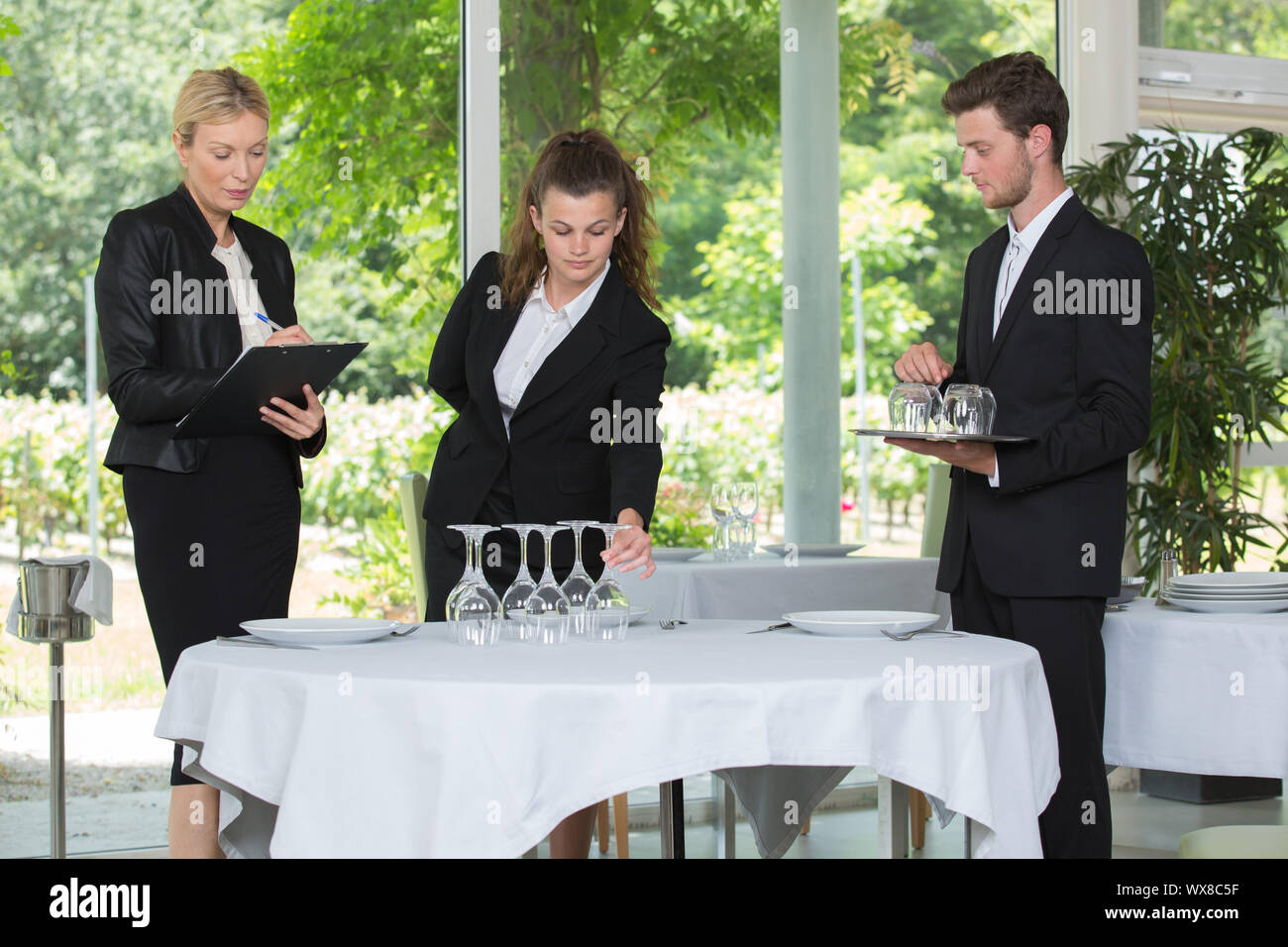 waiter setting a table in a bar Stock Photo - Alamy