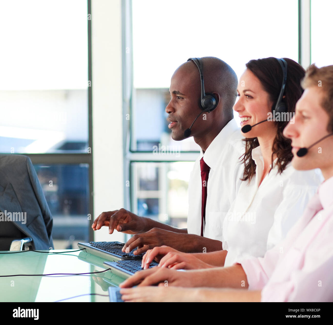 Happy people with a headset on working Stock Photo - Alamy