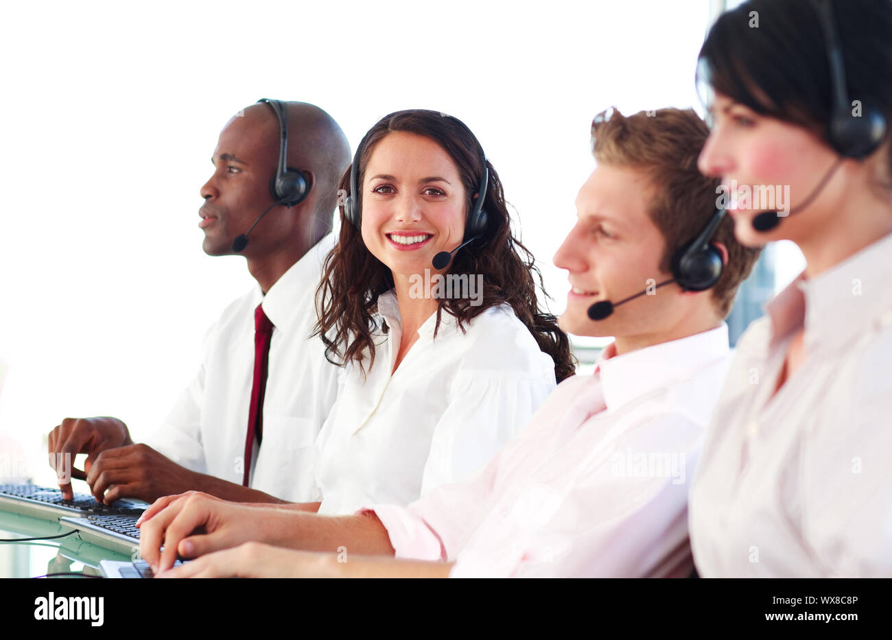 Smiling young people with a headset on working Stock Photo - Alamy