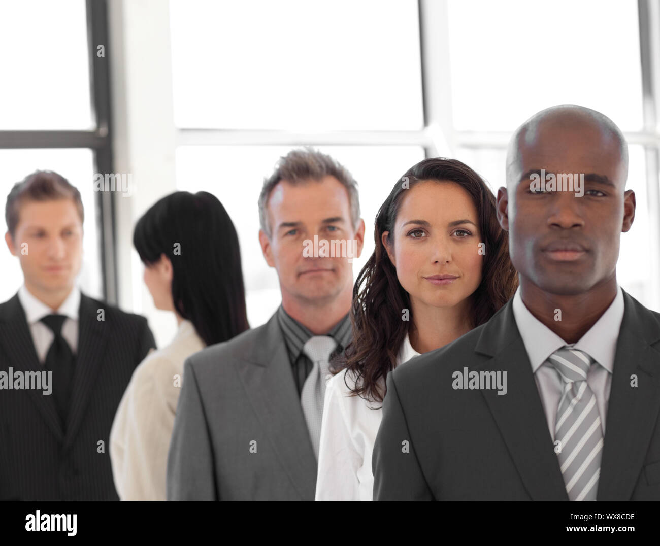 Serious business leader in front of business team Stock Photo - Alamy