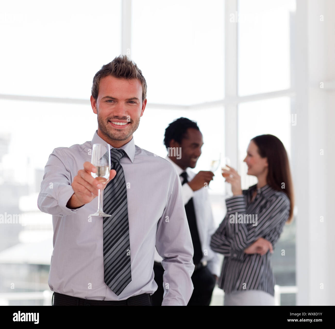Happy businessman celebrating a success with champagne in the office ...
