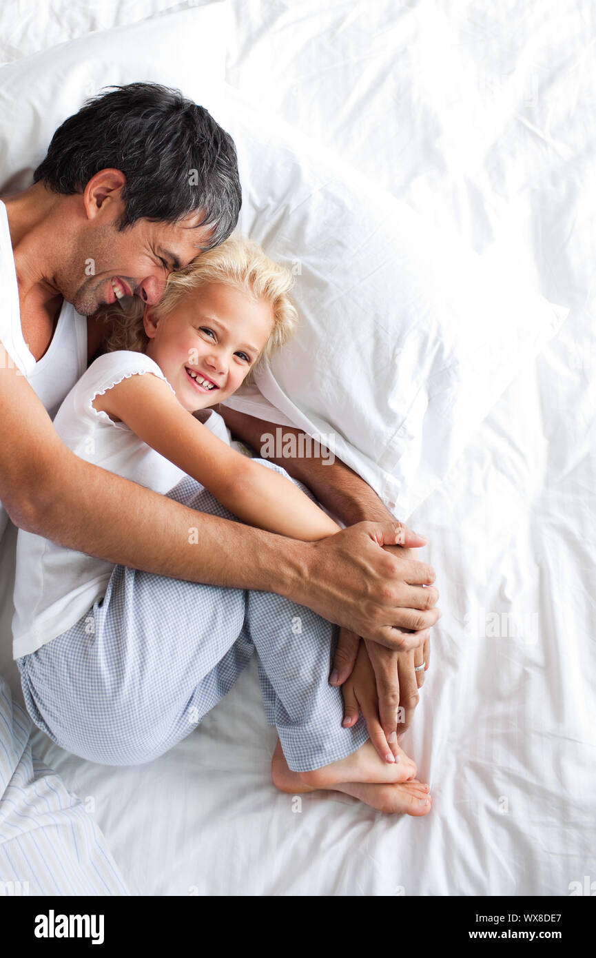 Father and daughter lying together on bed Stock Photo - Alamy