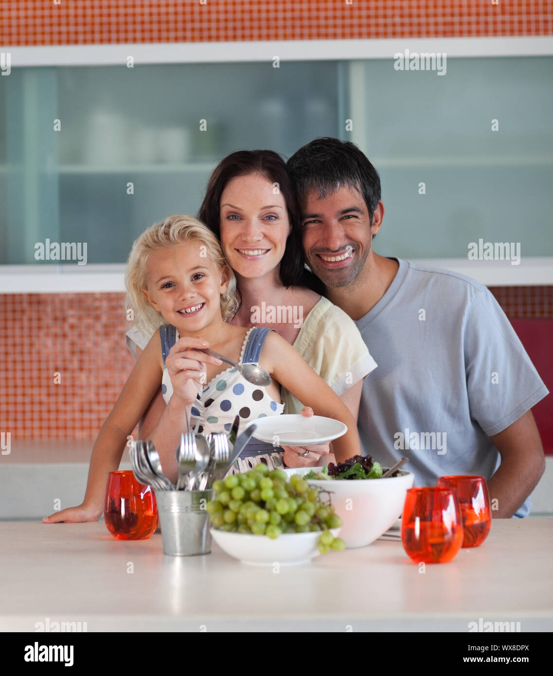 Smiling family eating in a kitchen Stock Photo - Alamy