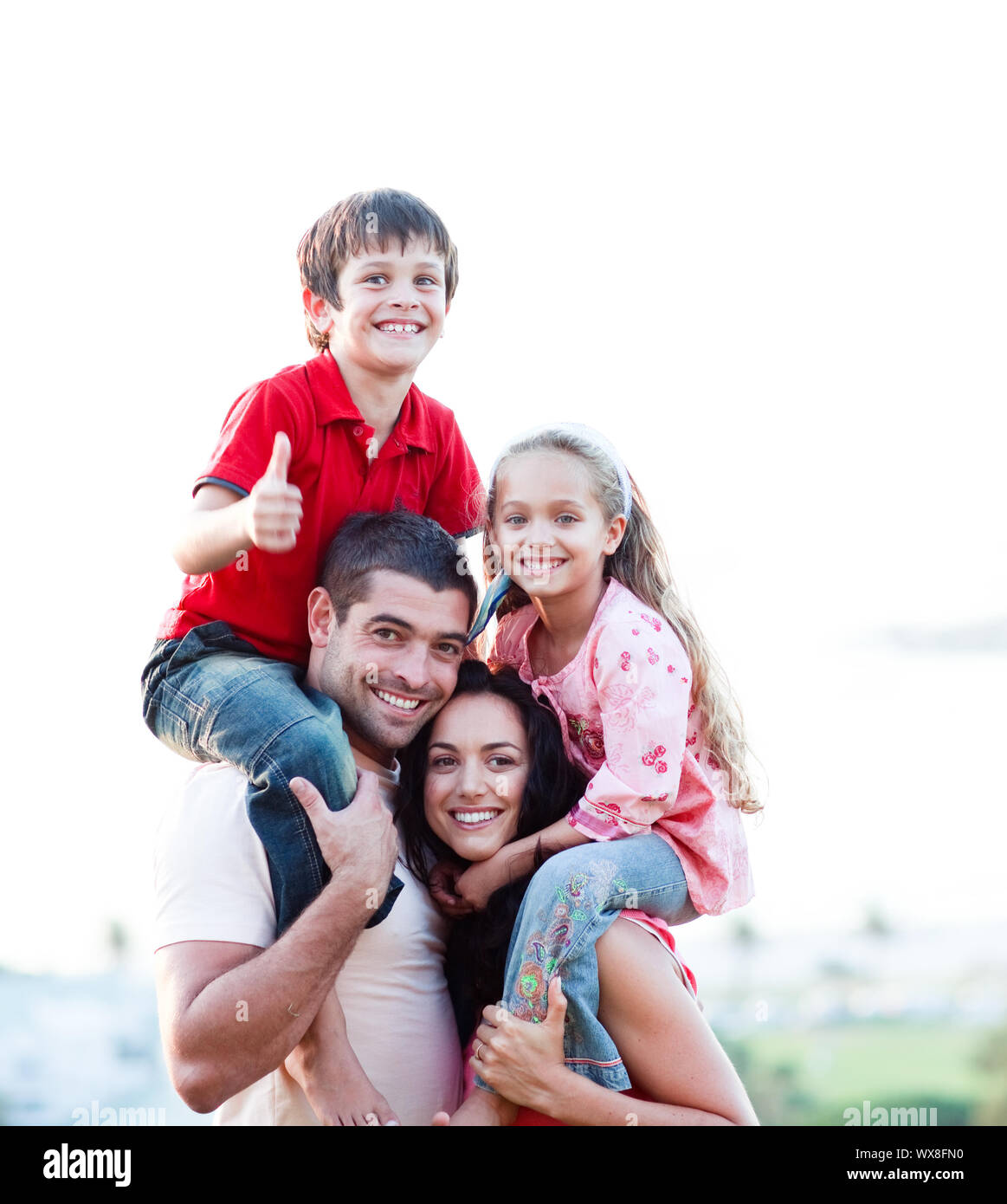 Parents giving children piggyback rides outdoors Stock Photo - Alamy