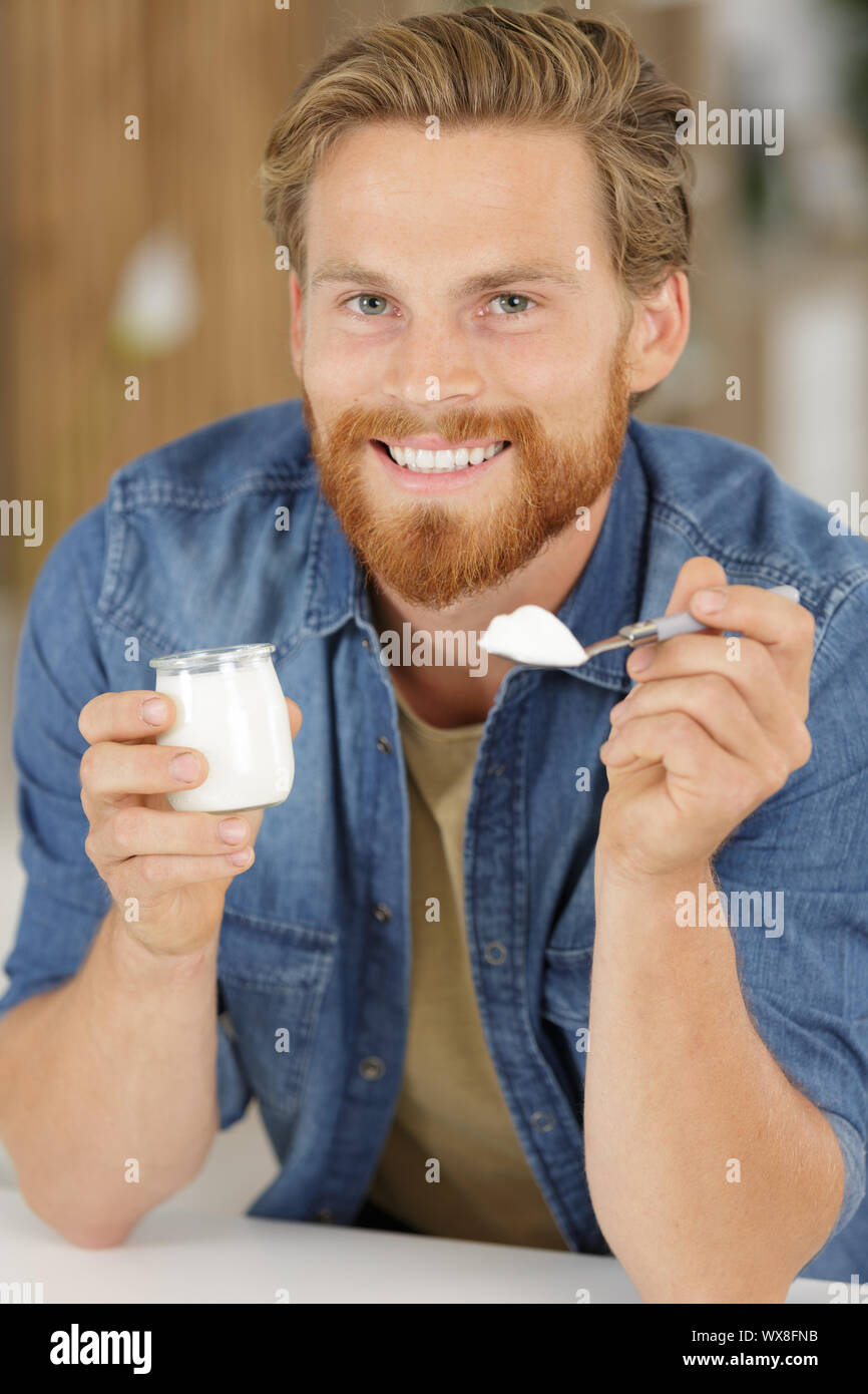 man eating a yogurt Stock Photo - Alamy