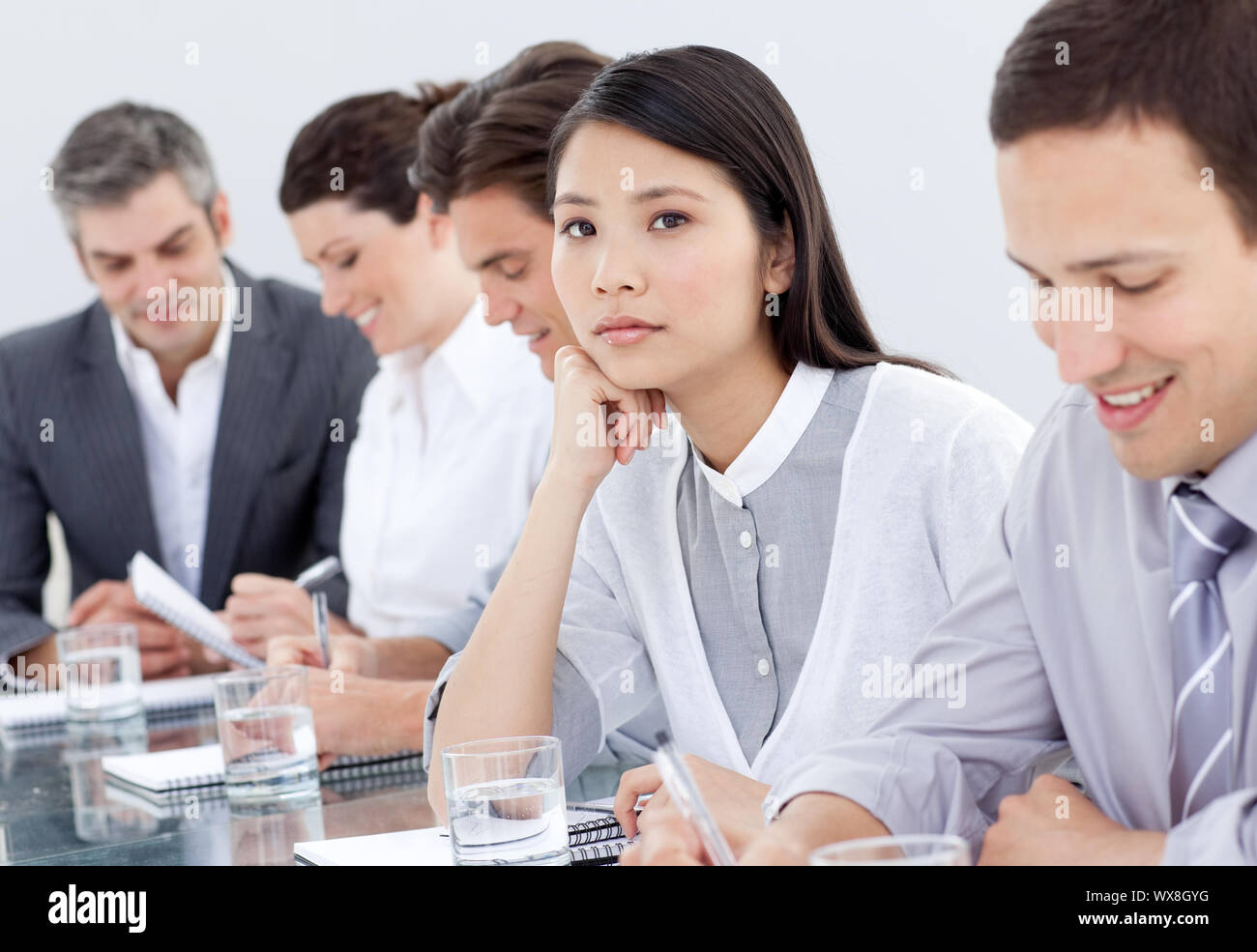 Bored asian businesswoman in a meeting with her team Stock Photo - Alamy