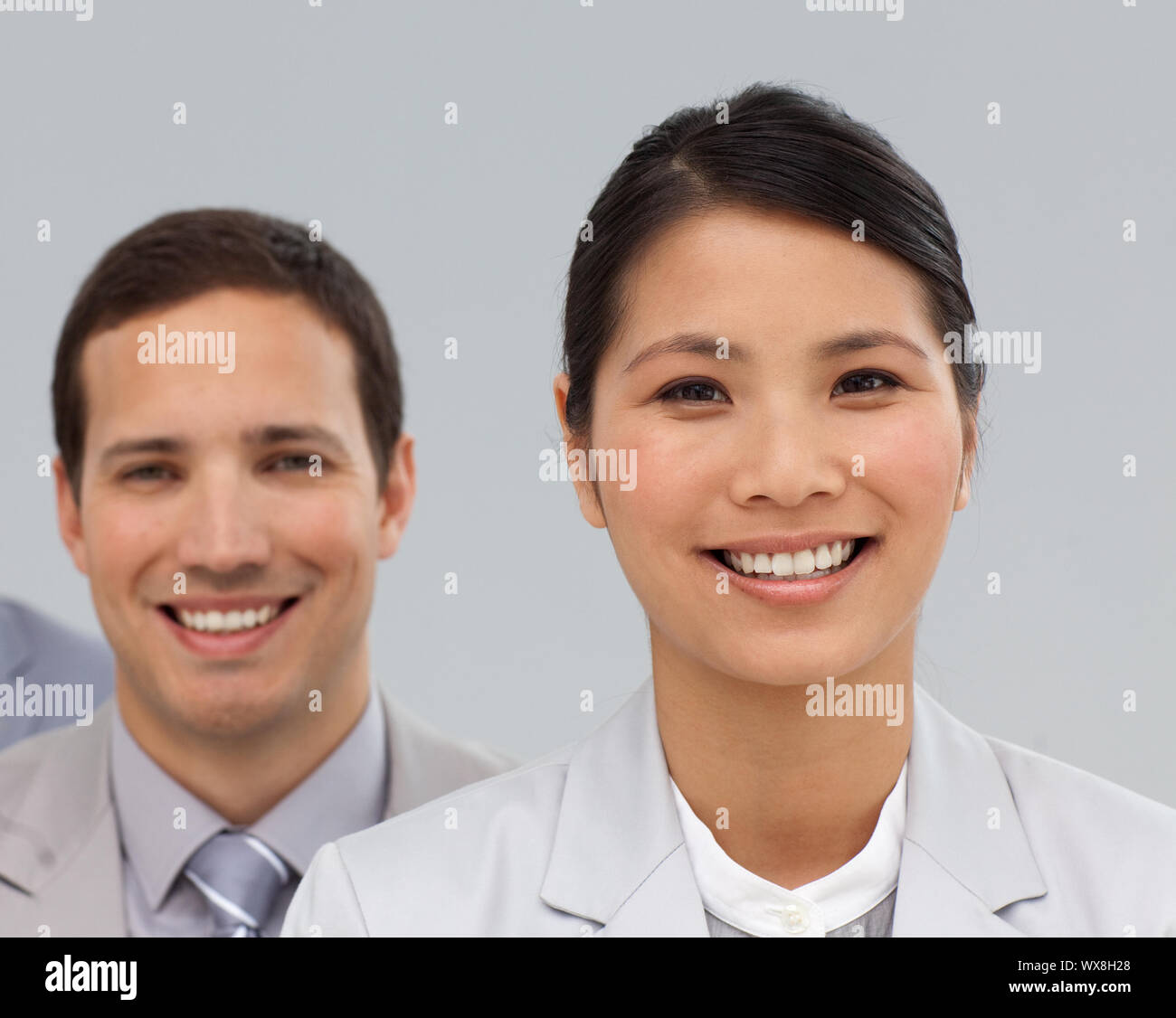 Close-up of two international co-workers smiling at the camera Stock ...