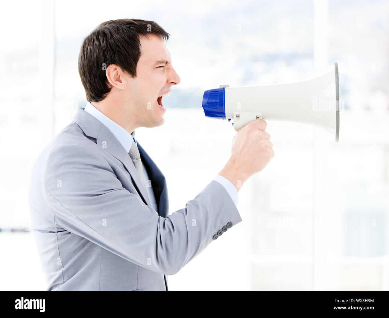 Portrait of an pretty businessman using a megaphone in the office Stock ...