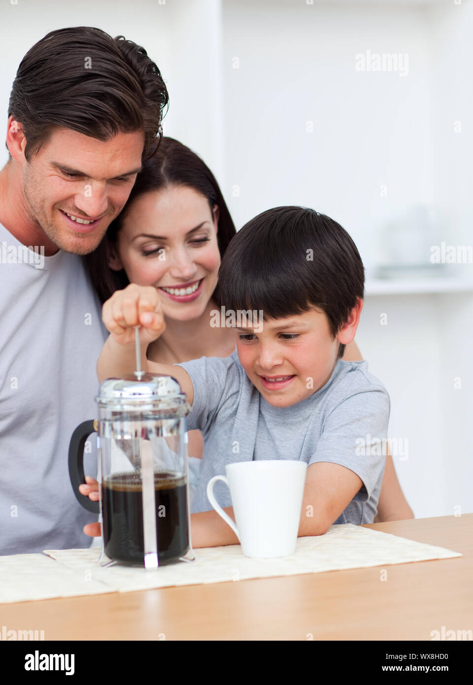 Happy boy preparing coffee with his parents in the kitchen Stock Photo ...