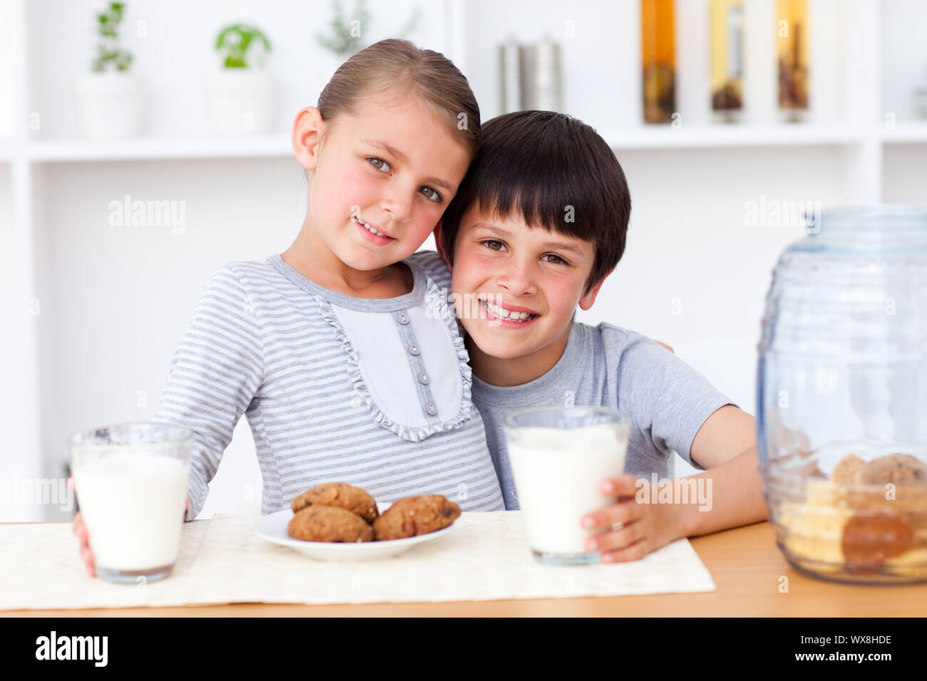 Portrait of happy siblings eating biscuits in the kitchen Stock Photo ...