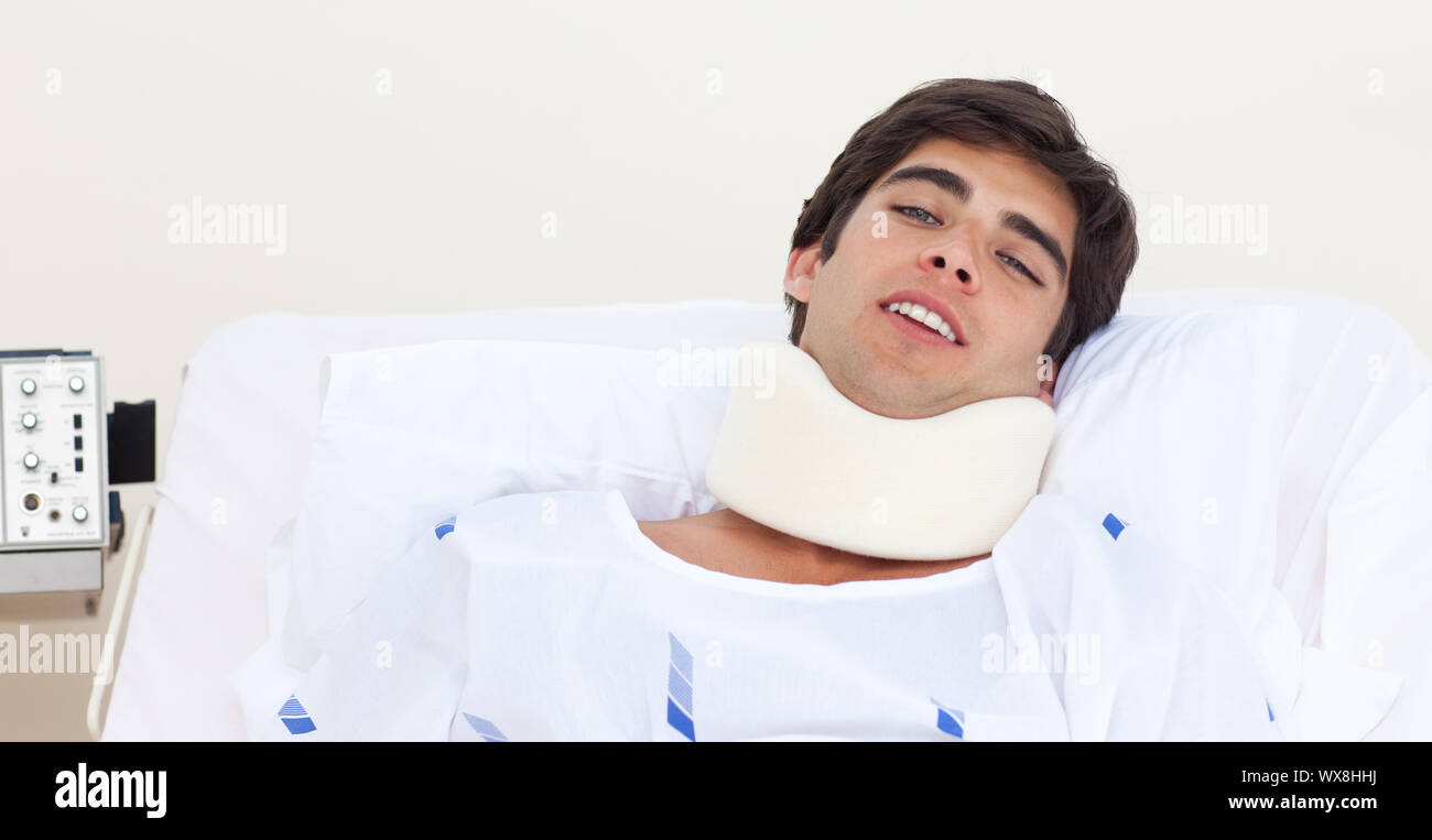 Male patient with a neck brace lying on a bed in the hospital Stock ...