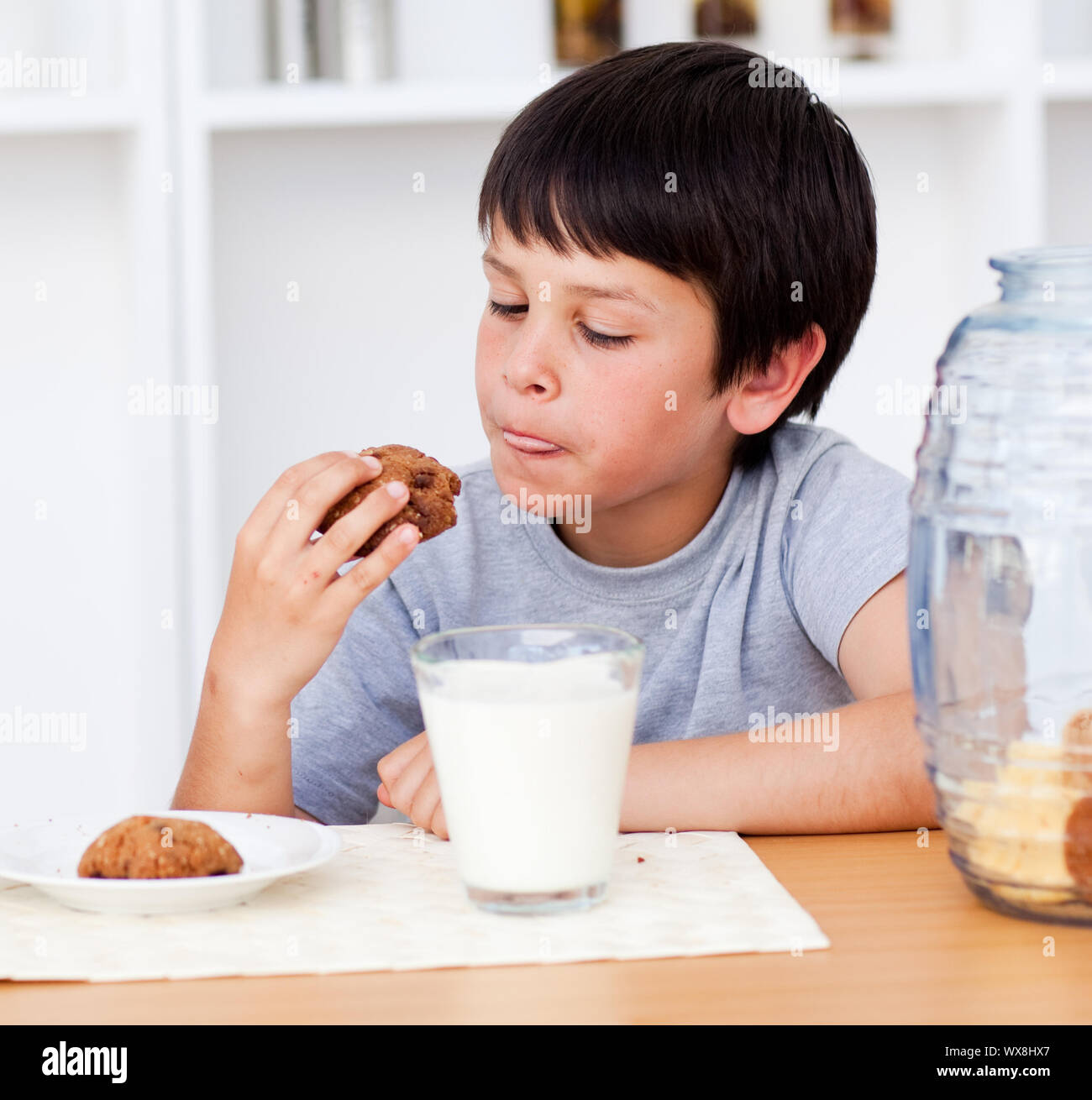 Young boy eating biscuits in the kitchen Stock Photo - Alamy