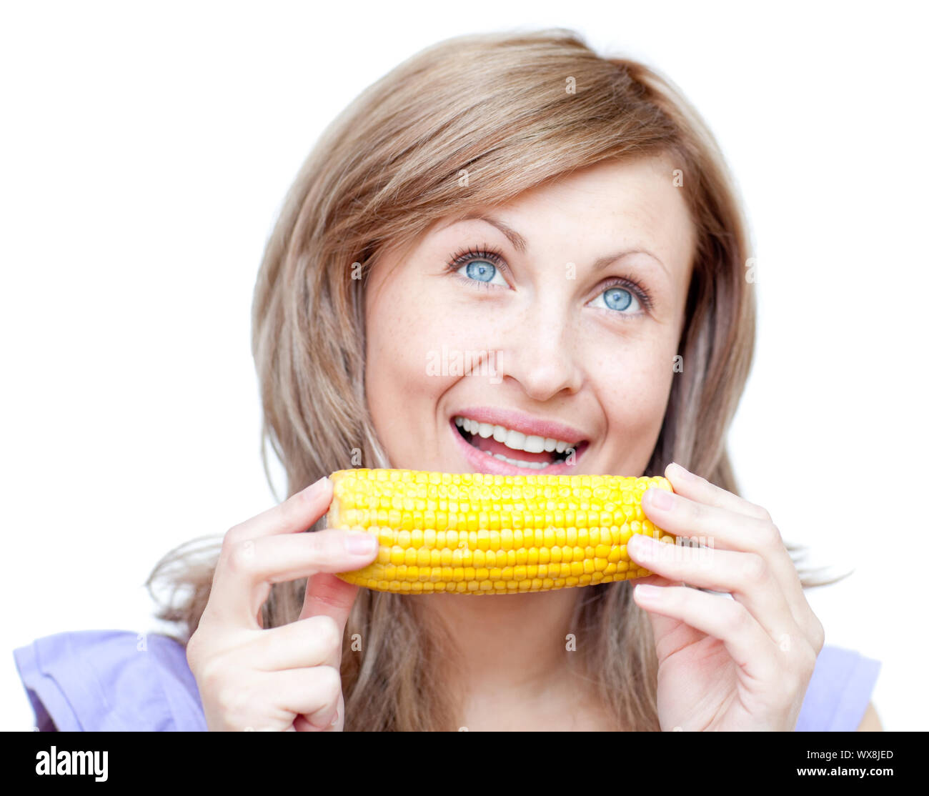 Radiant woman holding a corn against a white background Stock Photo - Alamy