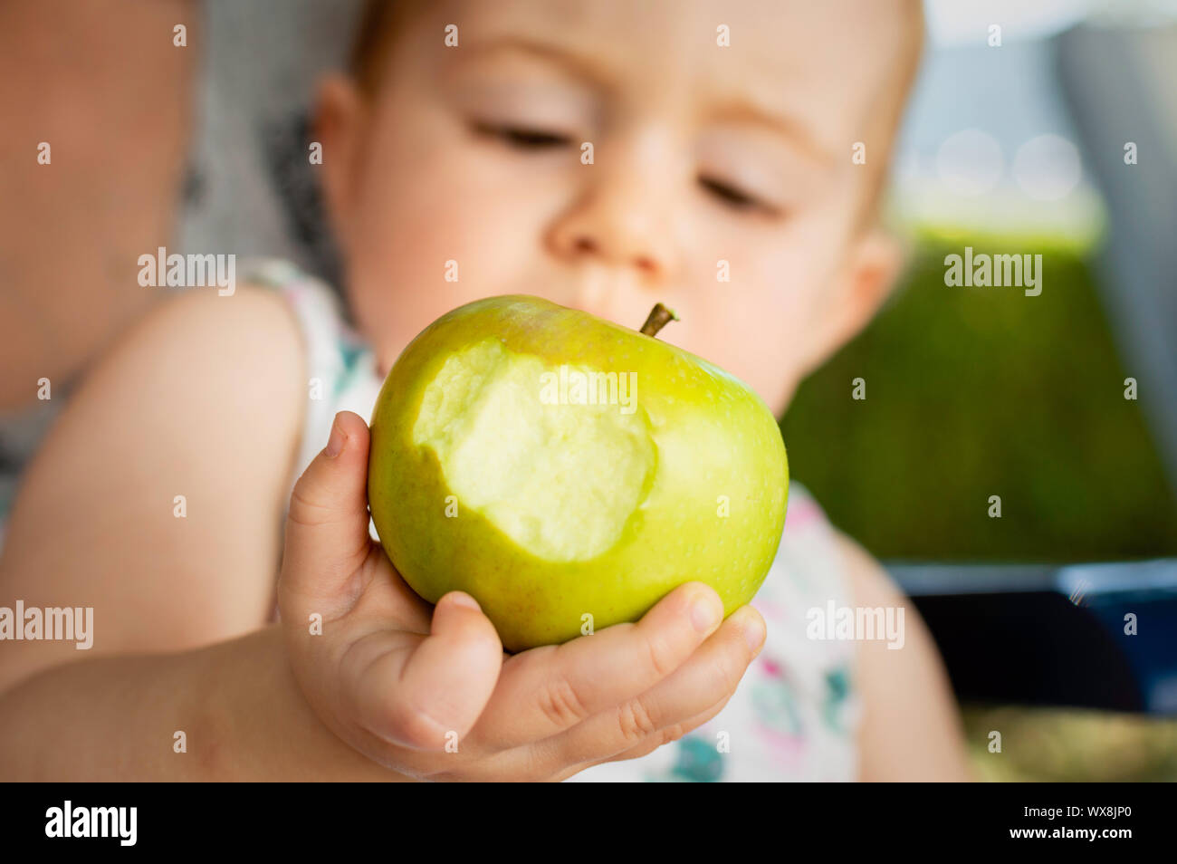 Little baby eating apple, closeup portrait, concept of health care ...