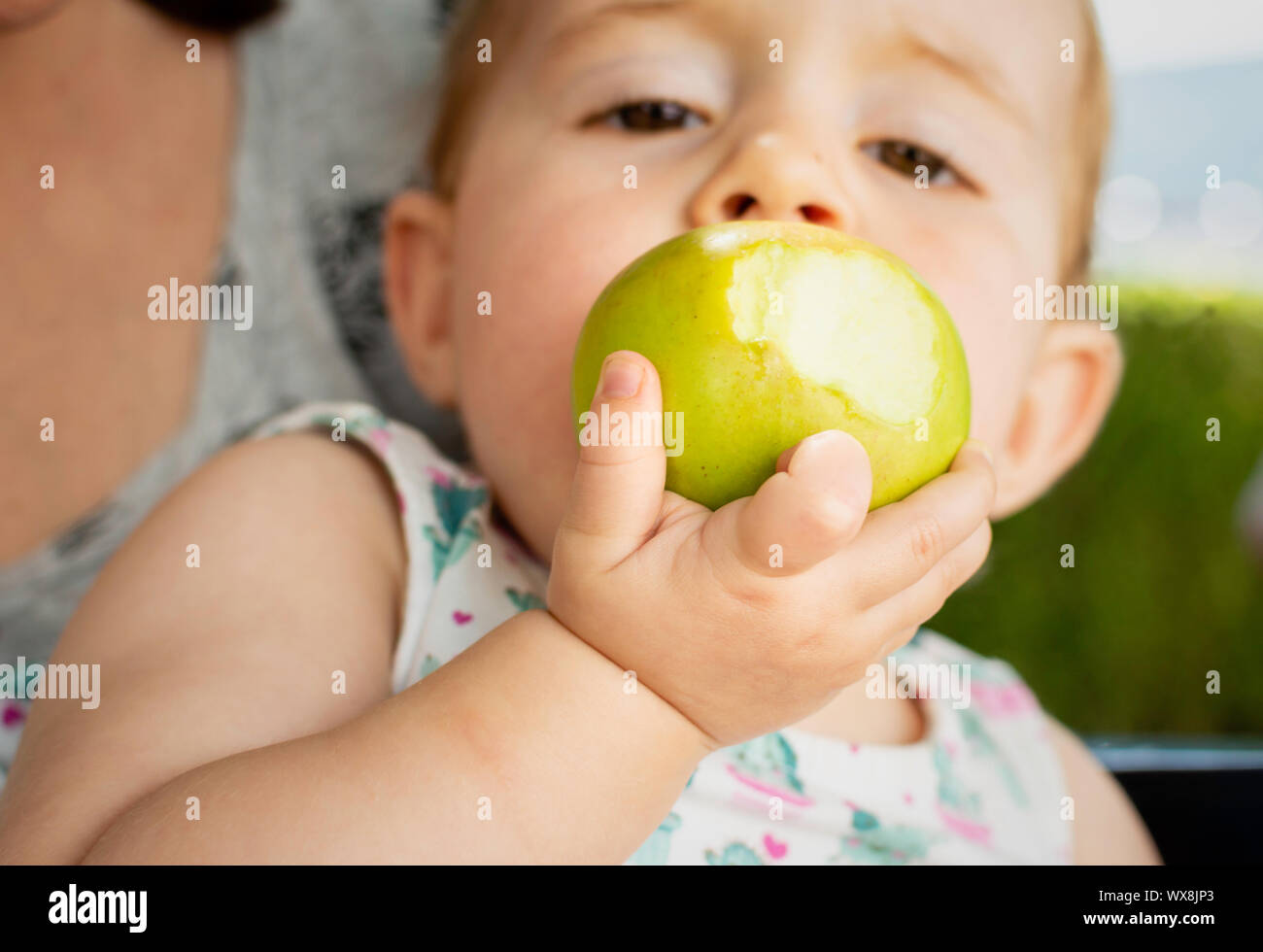Little baby eating apple, closeup portrait, concept of health care ...