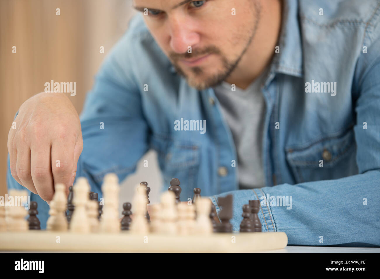 man playing chess next to board Stock Photo - Alamy