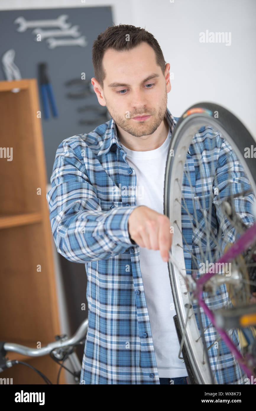 mechanic repairing bicycle wheel gear chain Stock Photo - Alamy