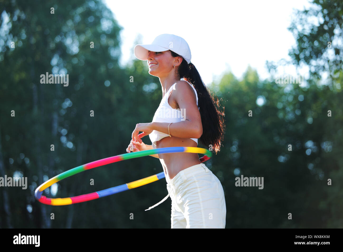 woman rotates hula hoop on nature background Stock Photo - Alamy
