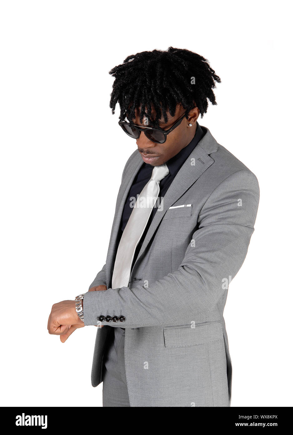 Black man standing looking at his watch Stock Photo - Alamy