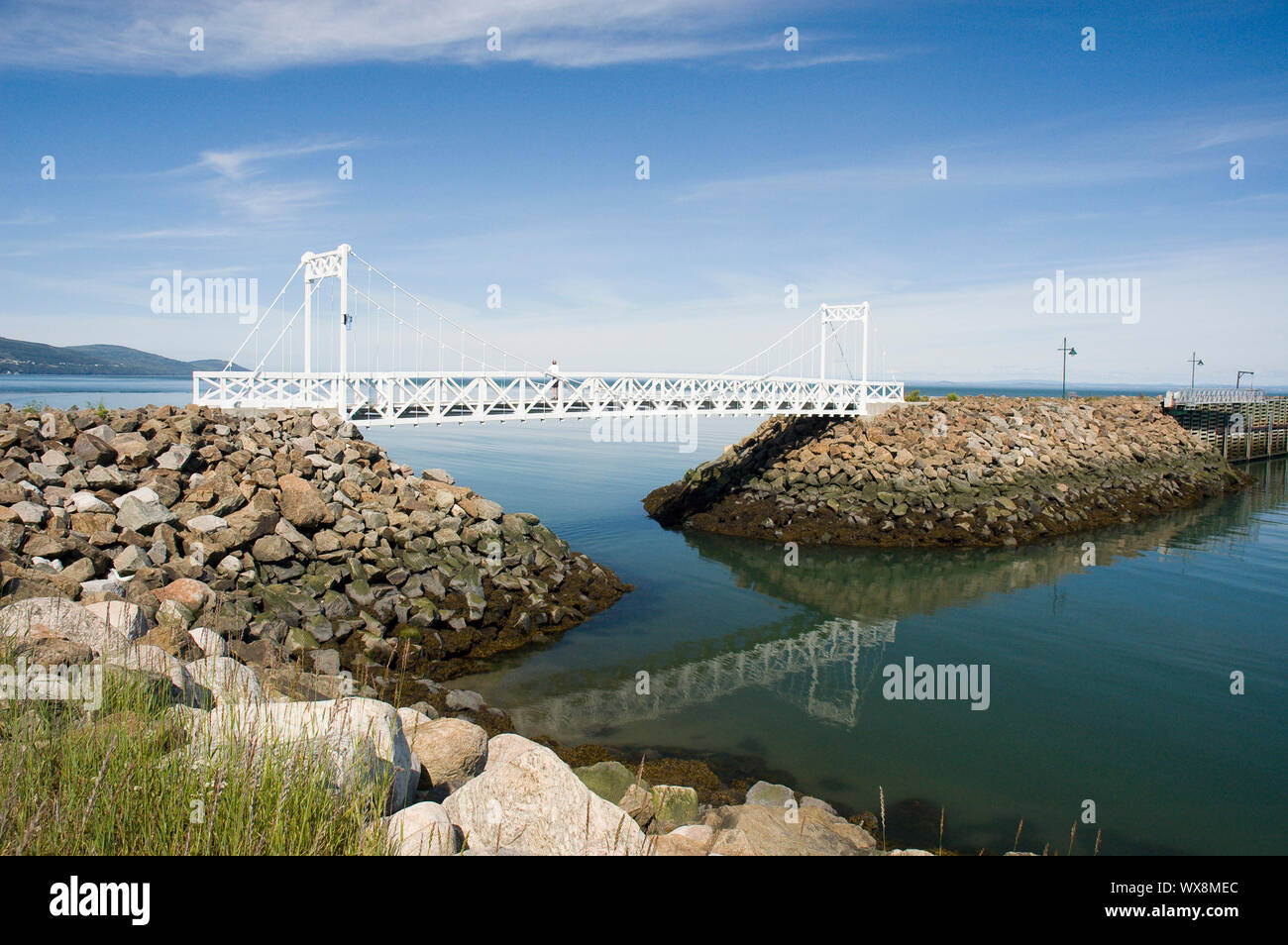 a small white bridge built on rocks Stock Photo - Alamy