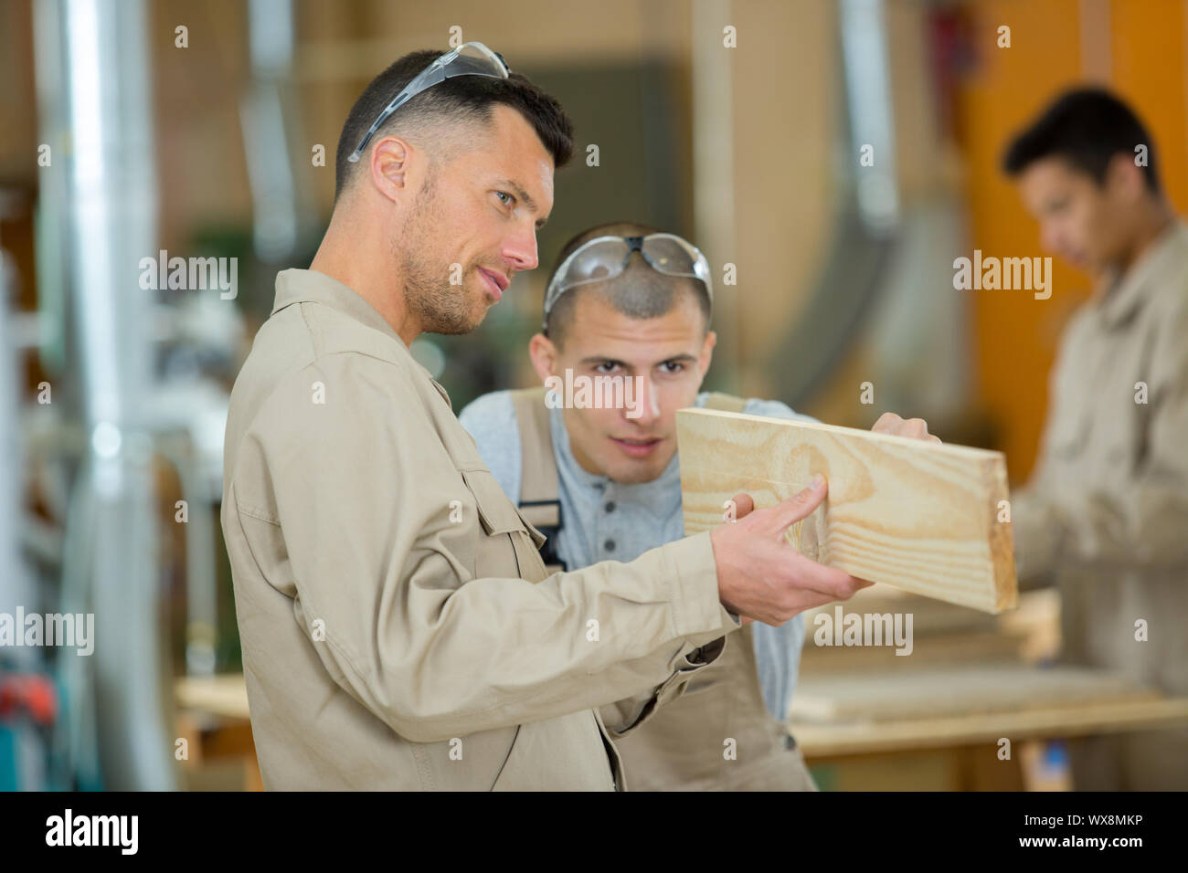 student and teacher looking at wood in carpentry class Stock Photo - Alamy