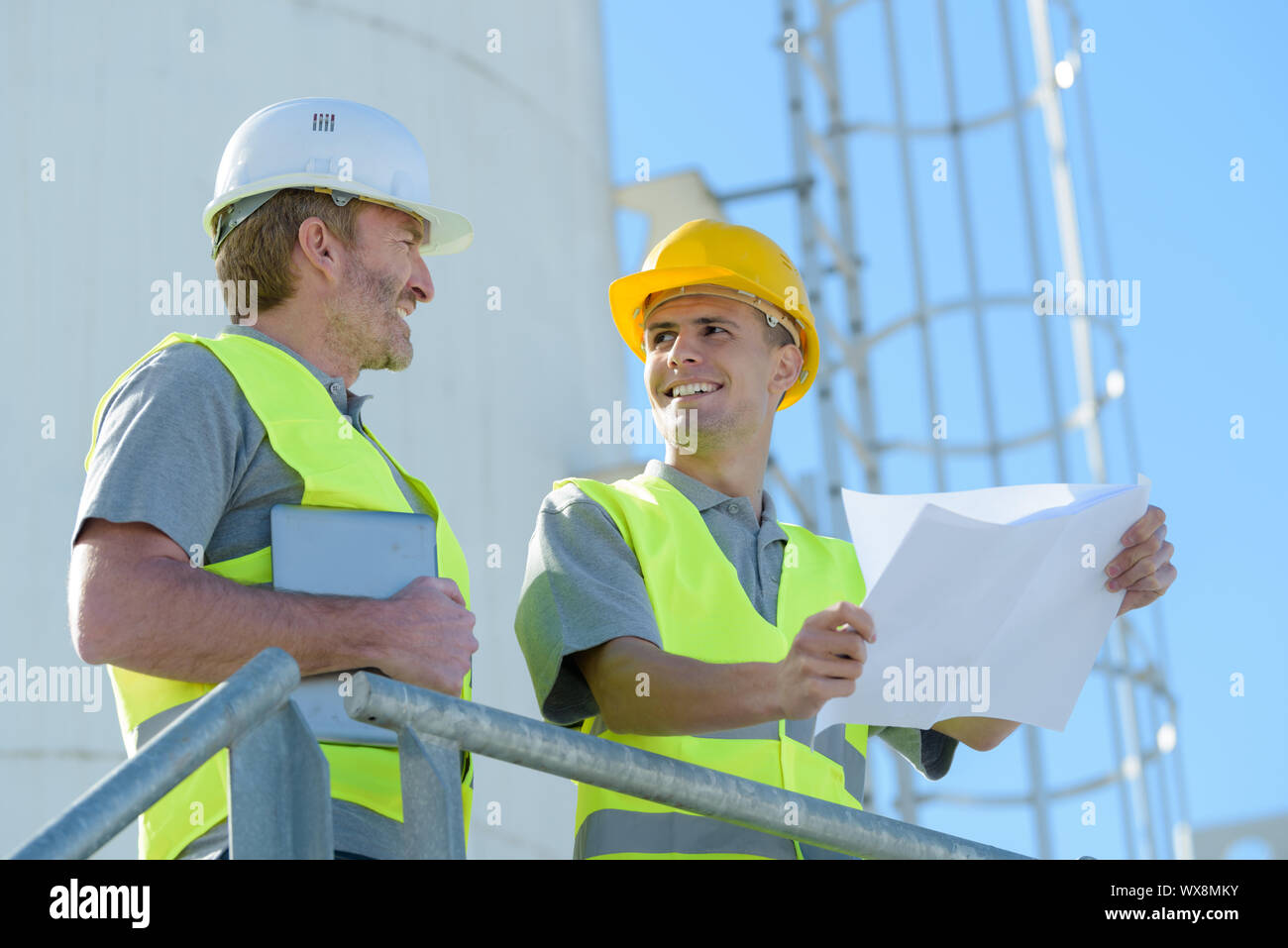 male workers looking at plans on outdoor site Stock Photo - Alamy