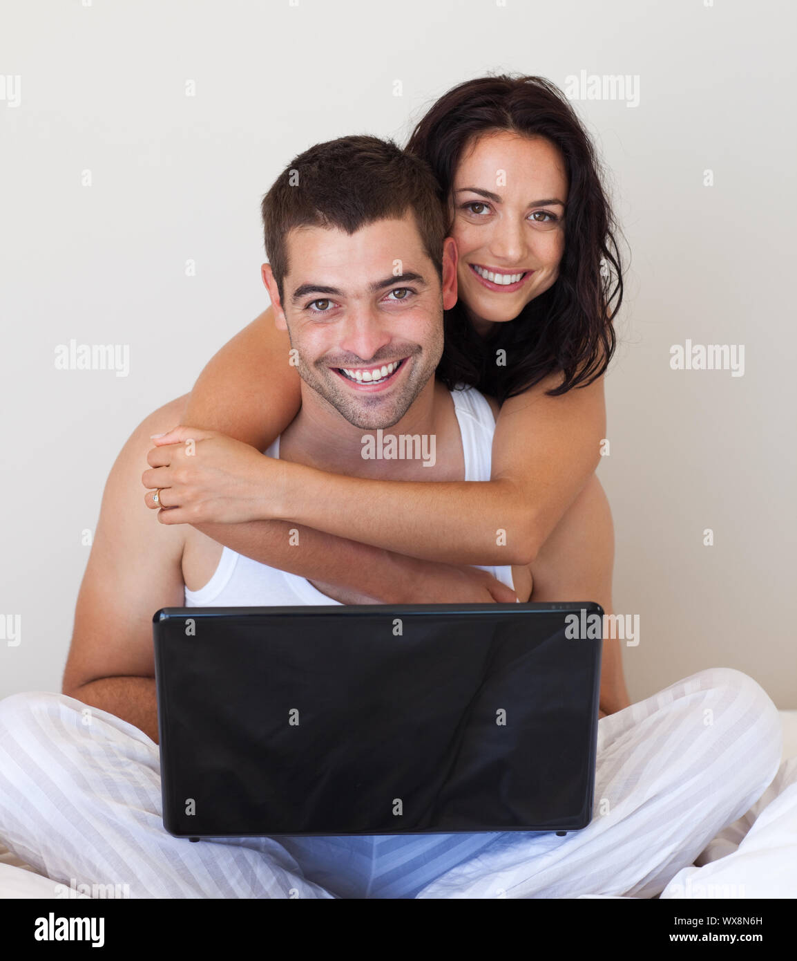 Romantic couple using laptop against white background Stock Photo - Alamy