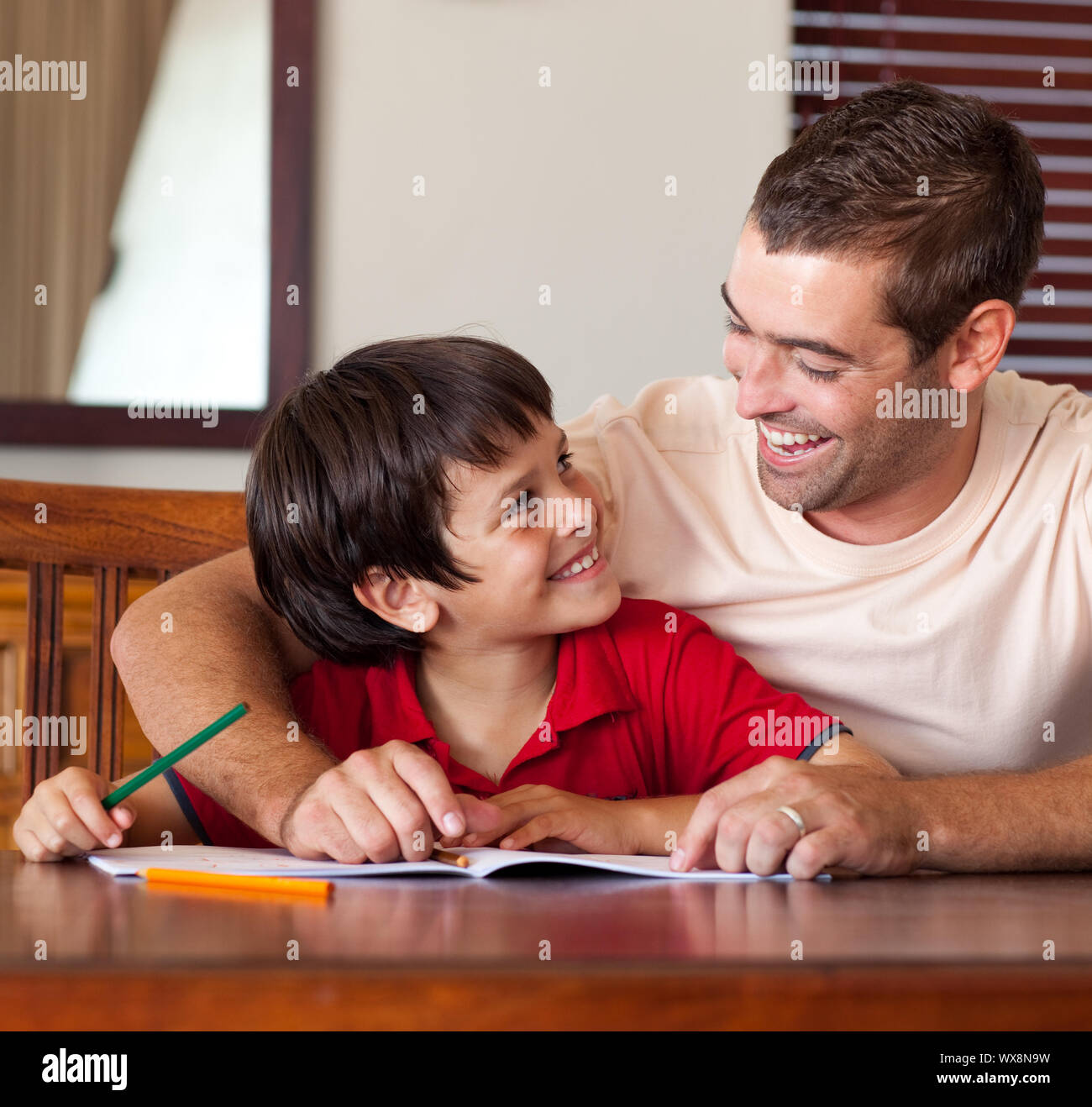 Cute boy looking at his father drawing a picture Stock Photo - Alamy
