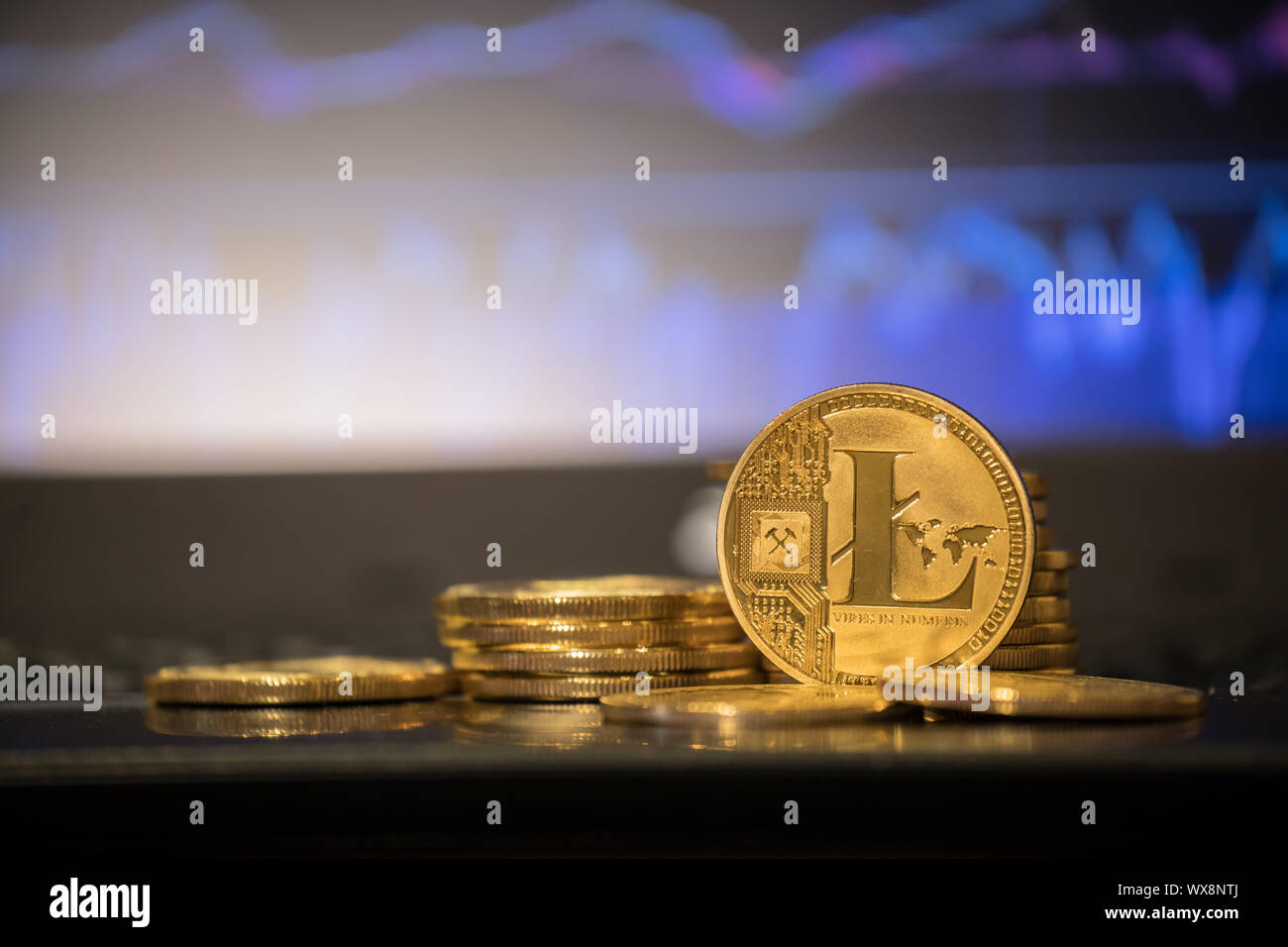 Golden Lightcoin on defocused blue chart background Stock Photo - Alamy