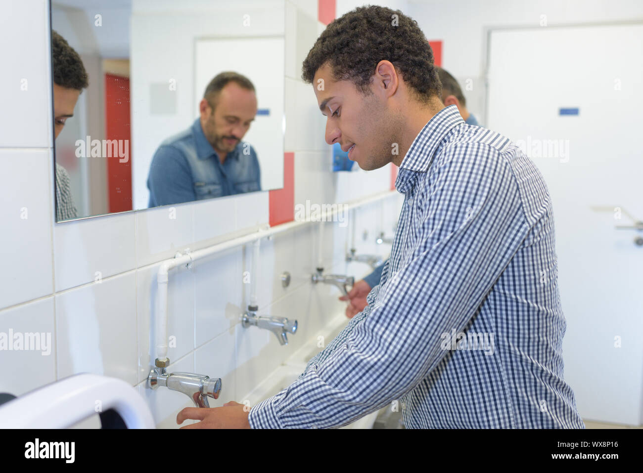 man washing hands in bathroom washbasin Stock Photo - Alamy