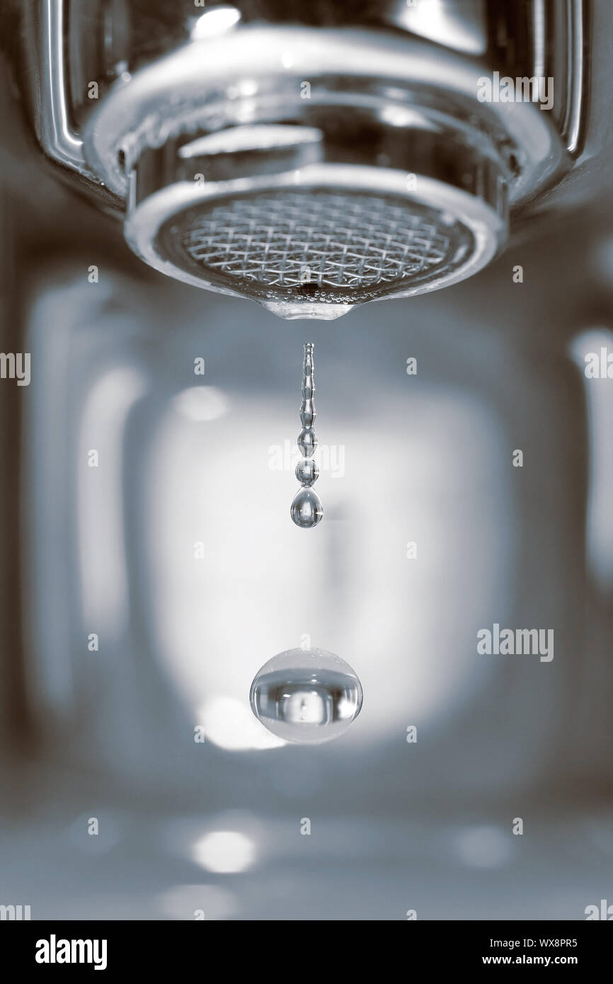 Water drop falling form a faucet in a bathroom, low depth of field ...
