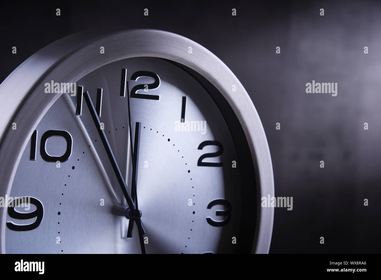 Modern wall clock showing five to twelve Stock Photo - Alamy