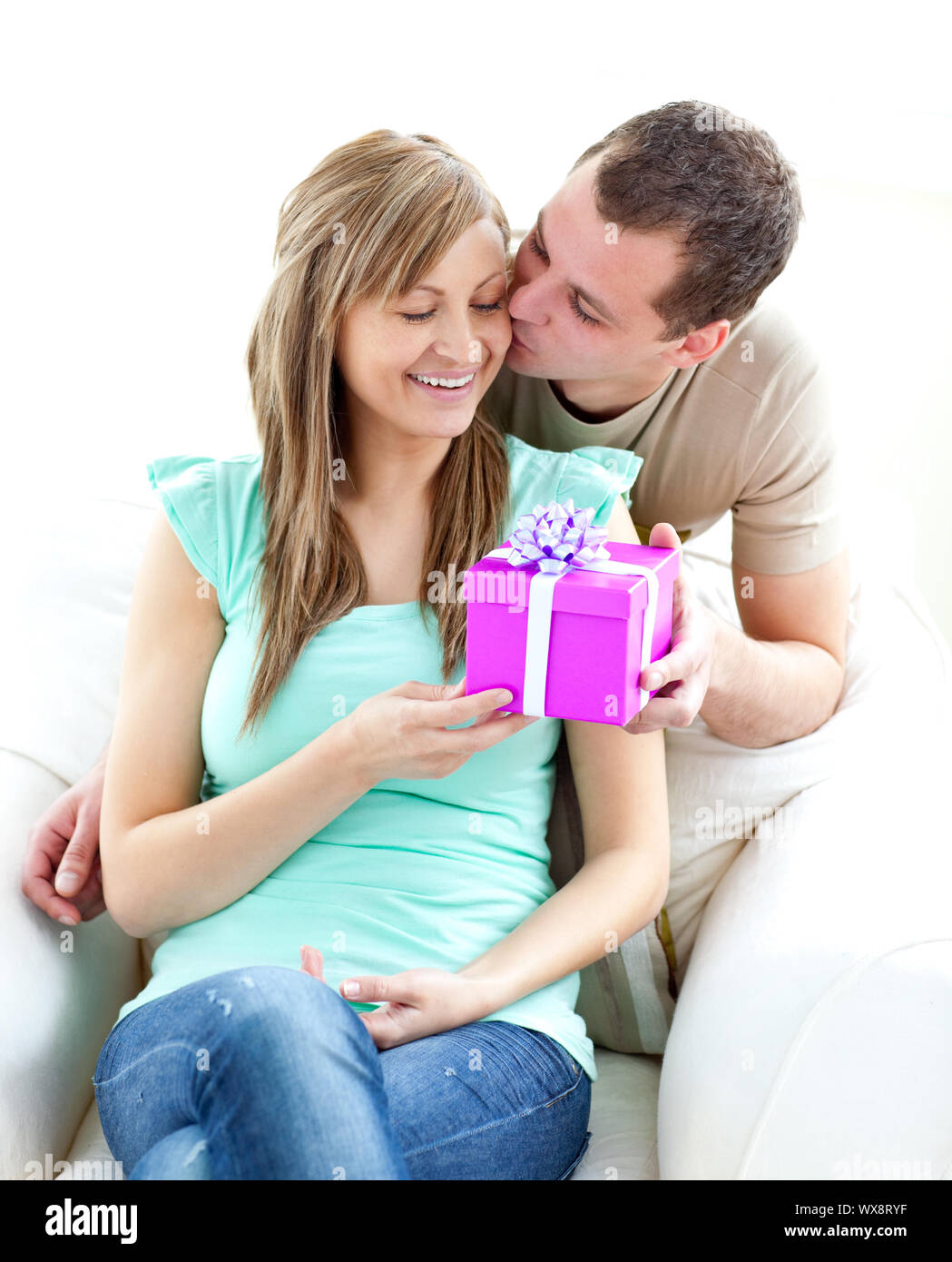 Attractive boyfriend giving a present and a kiss to his glowing ...