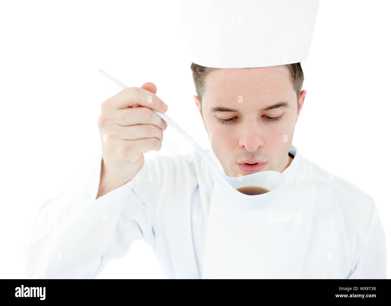 Serious cook tasting a soup against white background Stock Photo - Alamy