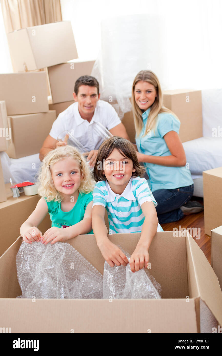 Smiling family packing boxes while moving house Stock Photo - Alamy