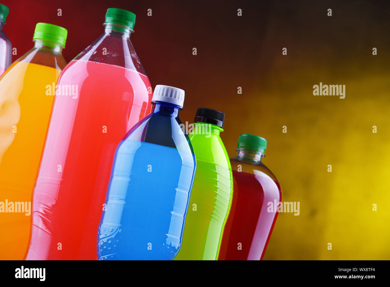 Plastic bottles of assorted carbonated soft drinks in variety of colors ...