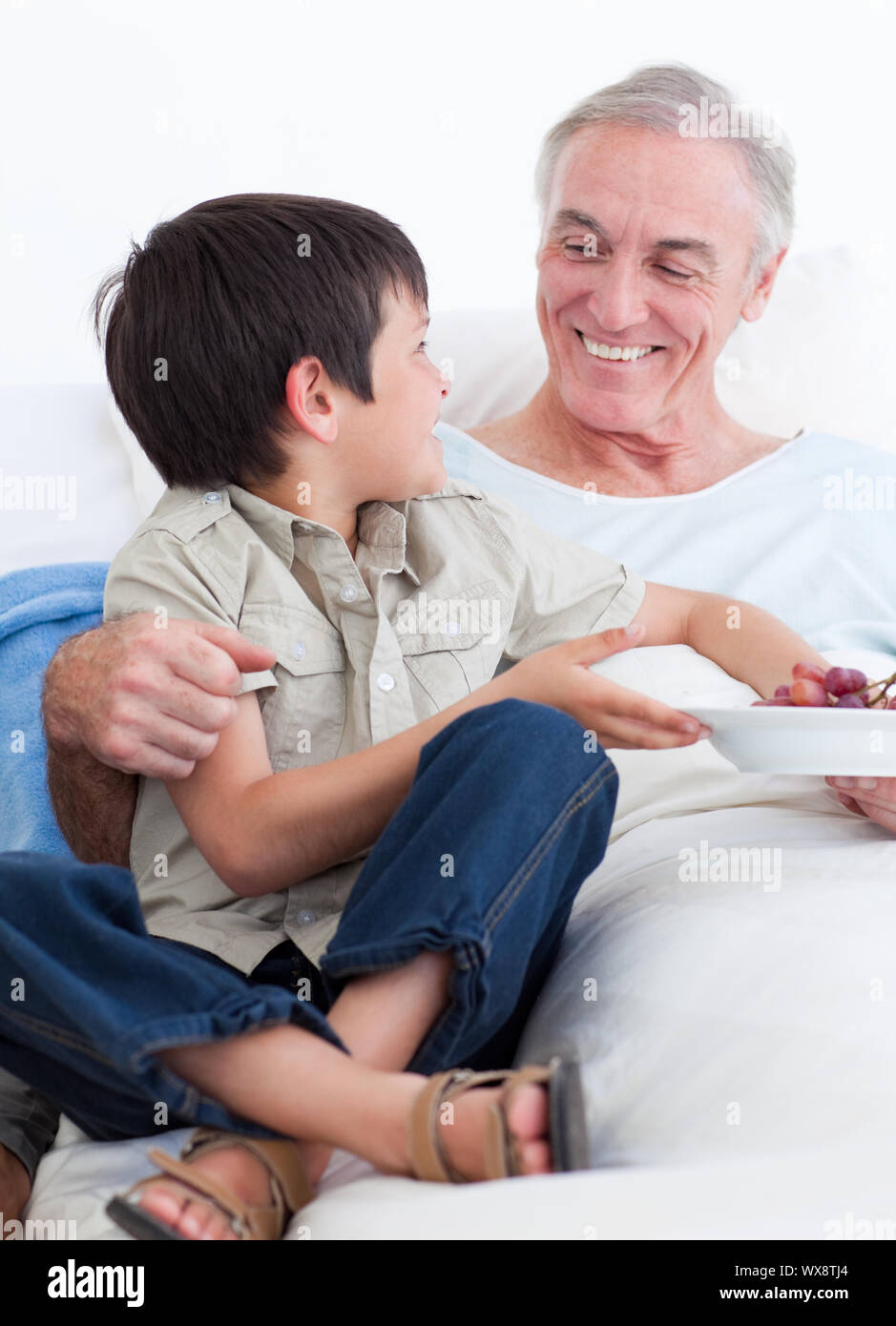 Adorable little boy taking care of his grandfather at the hospital ...
