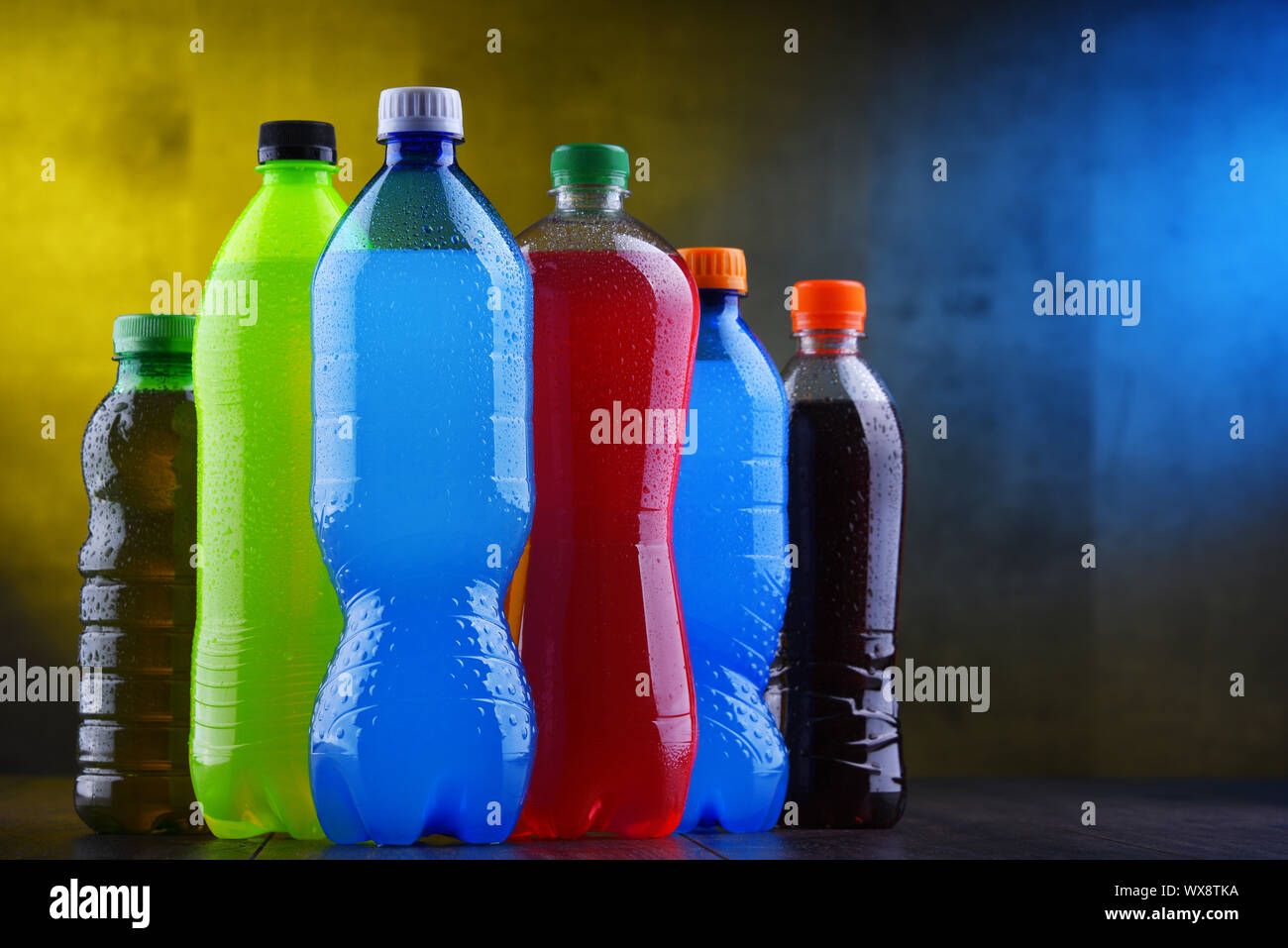 Plastic bottles of assorted carbonated soft drinks in variety of colors ...