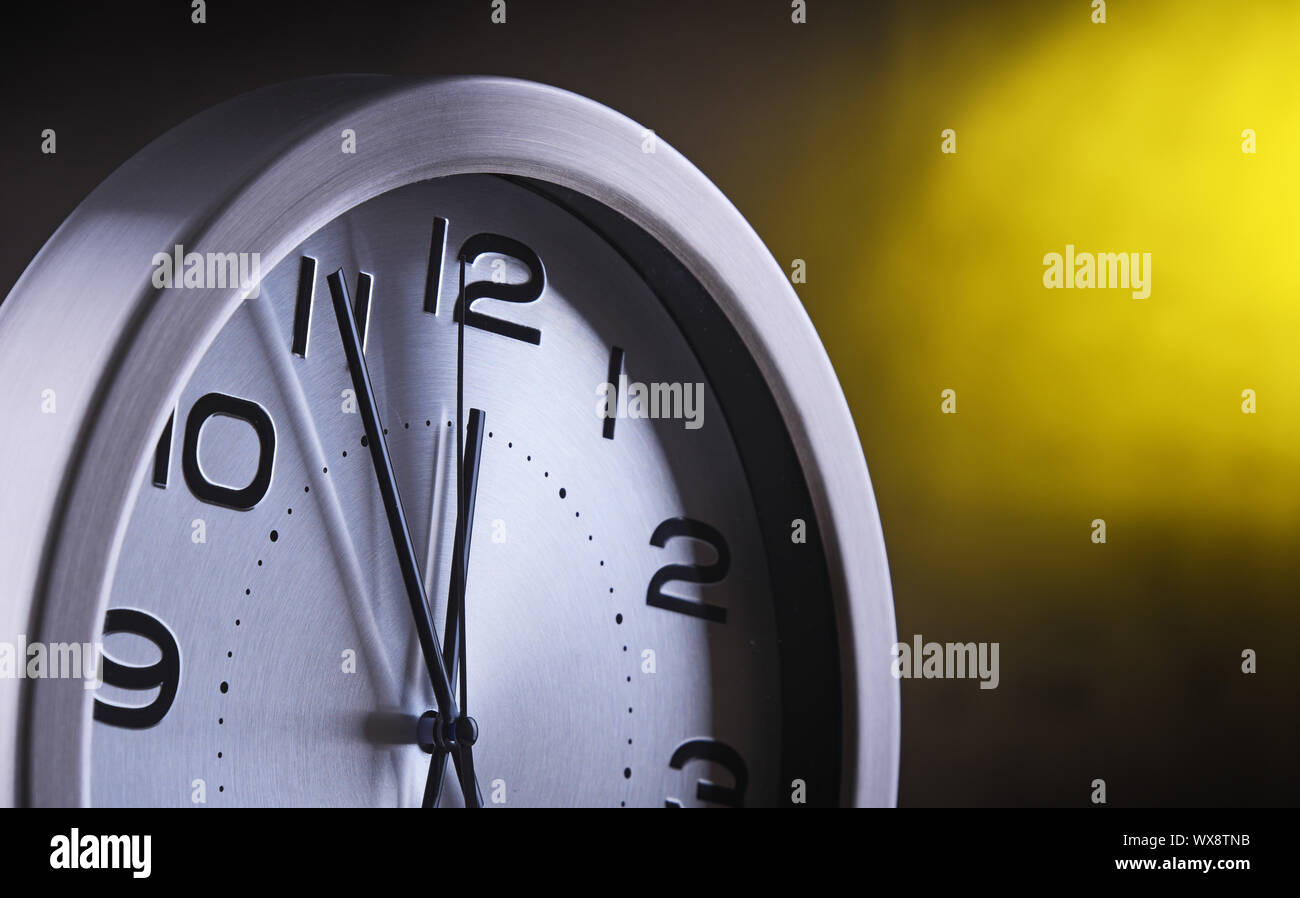 Modern wall clock showing five to twelve Stock Photo - Alamy