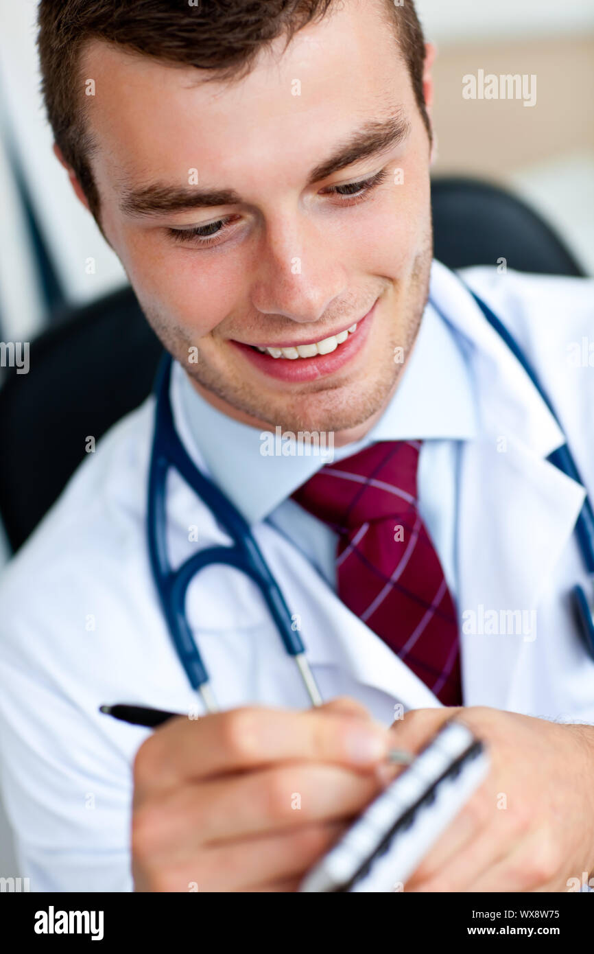 Caucasian male doctor writing a perscription in his office Stock Photo ...