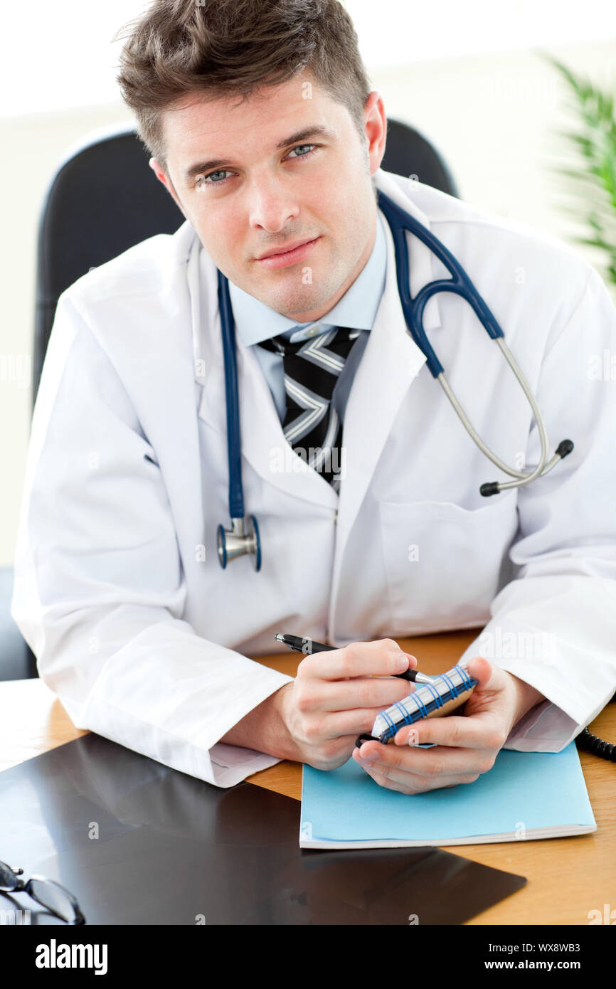 Portrait a charismatic male doctor writing notes Stock Photo - Alamy