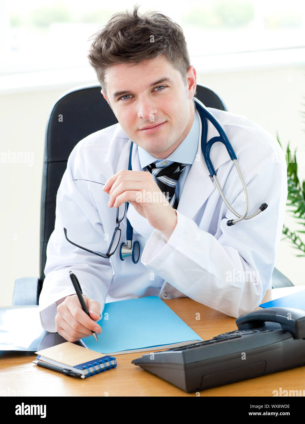 Portrait a charming male doctor writing notes Stock Photo - Alamy