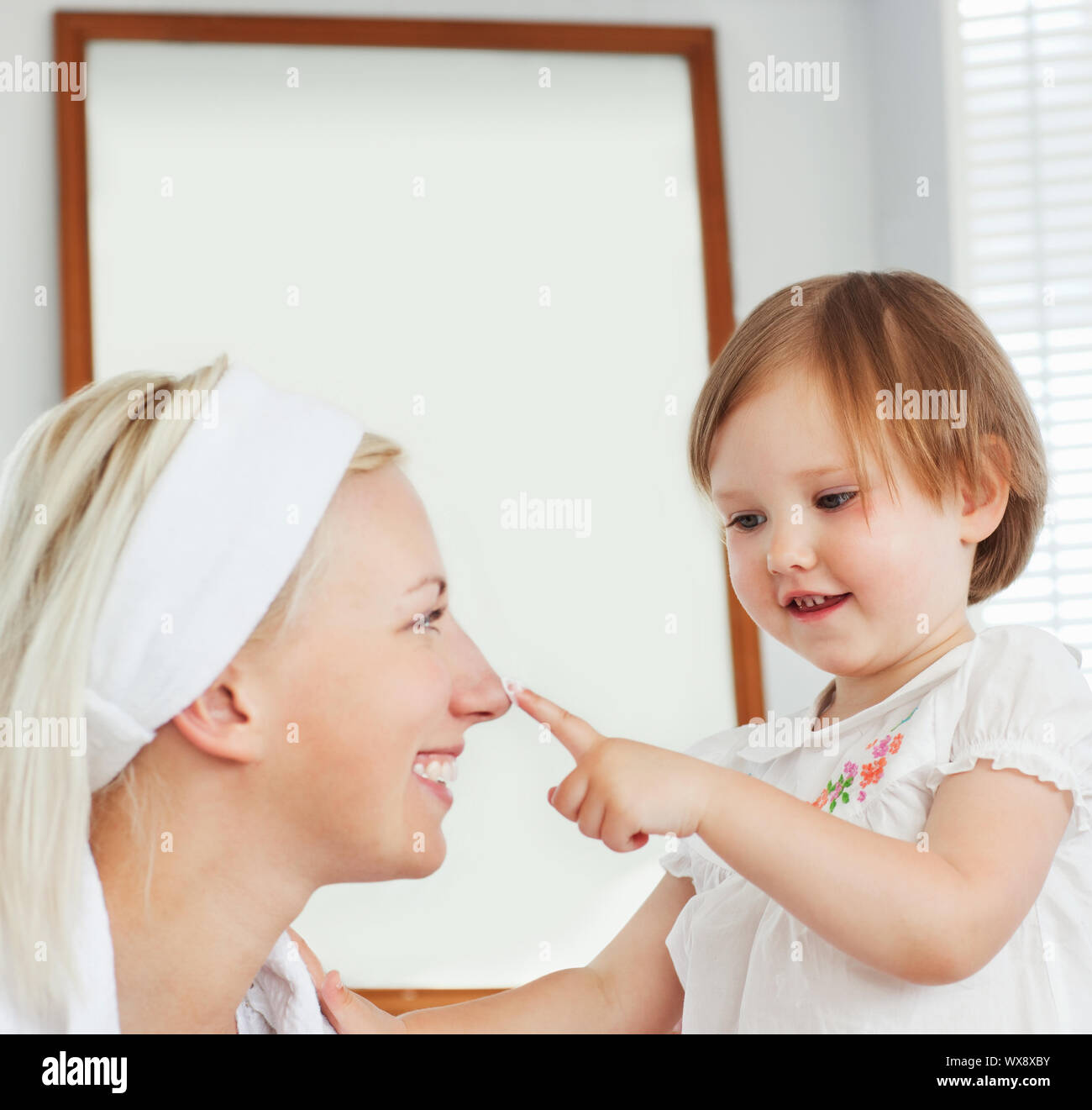 Beautiful mother taking care of her child at home Stock Photo - Alamy