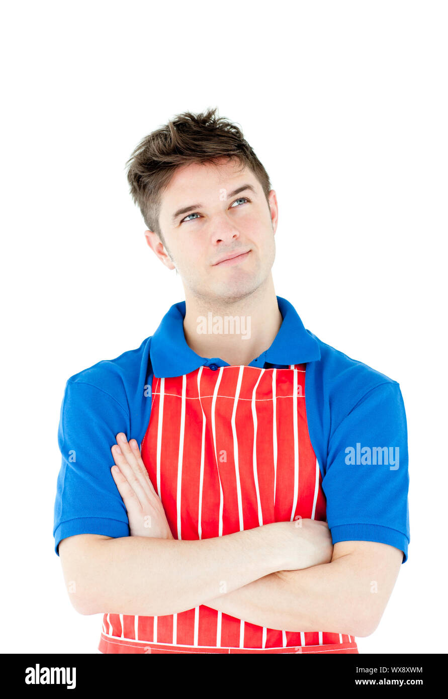 Serious young cook wearing a apron with folded arms against white ...