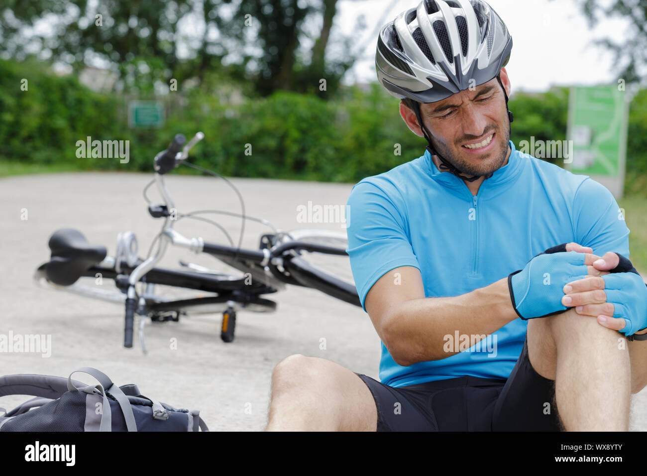 cyclist fell down from bike with injured knee Stock Photo - Alamy