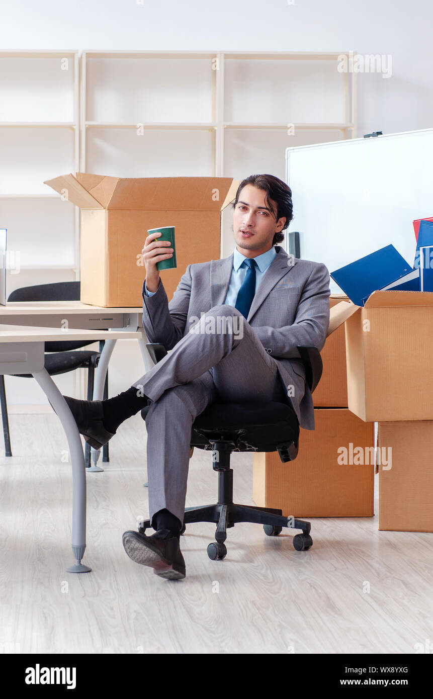 Young man employee with boxes in the office Stock Photo - Alamy