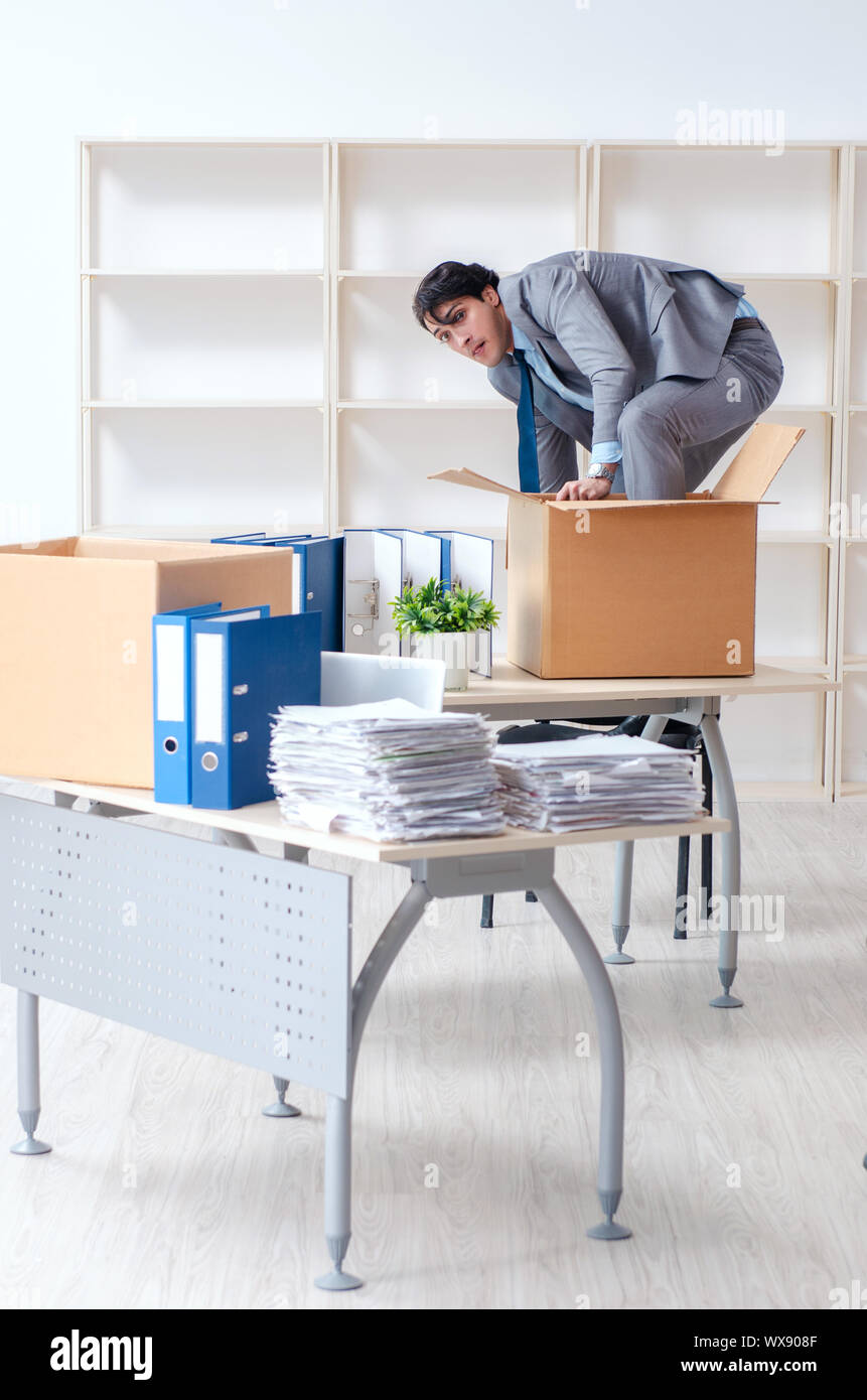 Young man employee with boxes in the office Stock Photo - Alamy